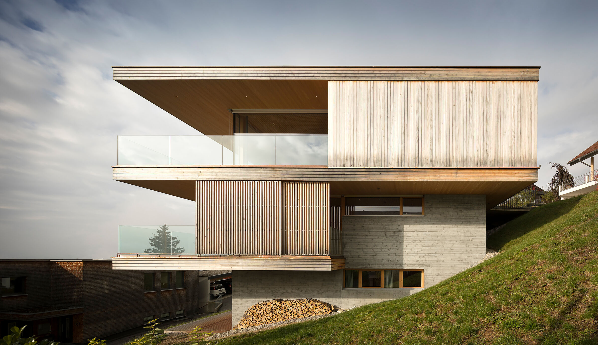 Light and transparent House K elegantly navigates a steeply sloping ...