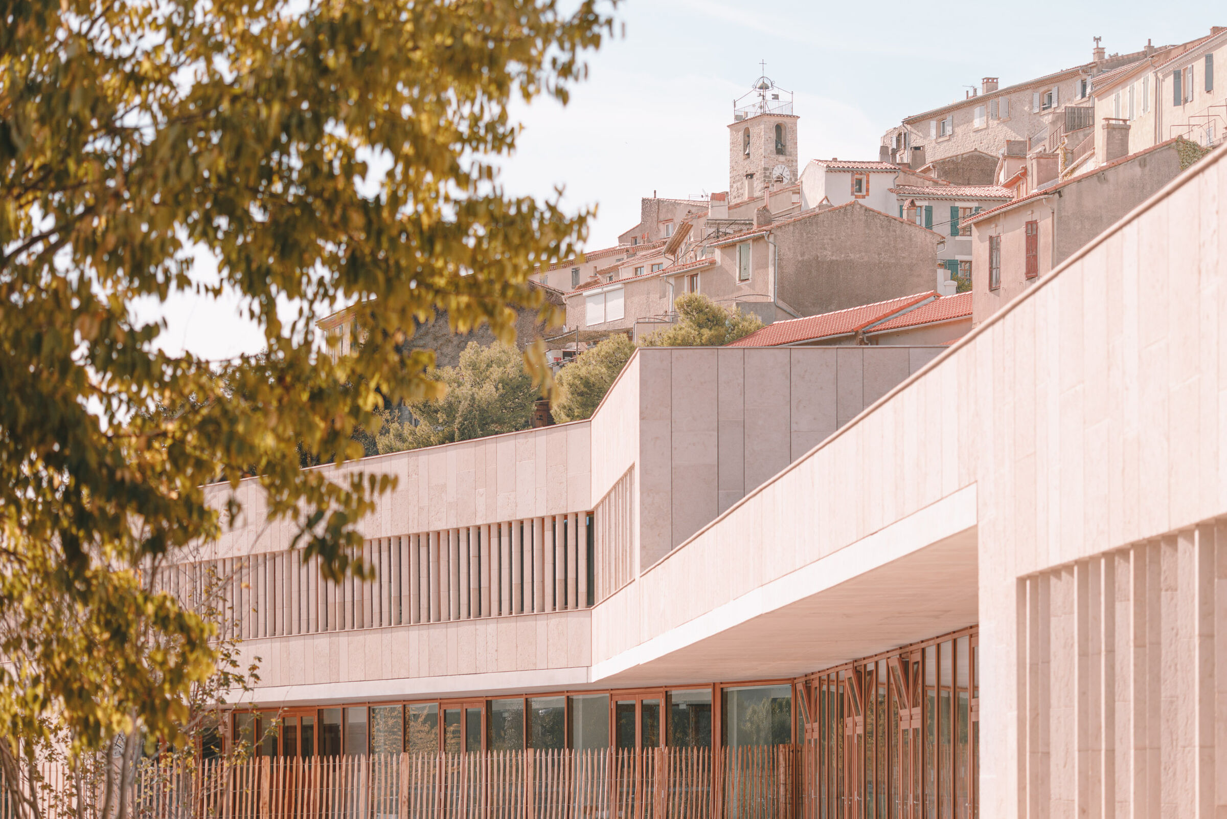 Amelia Tavella Architectes completes an elongated school of stone ...